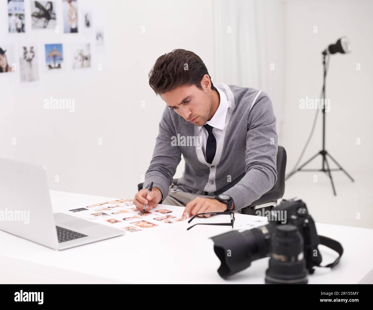 Working on the final edit. a young photographer sitting at his desk ...