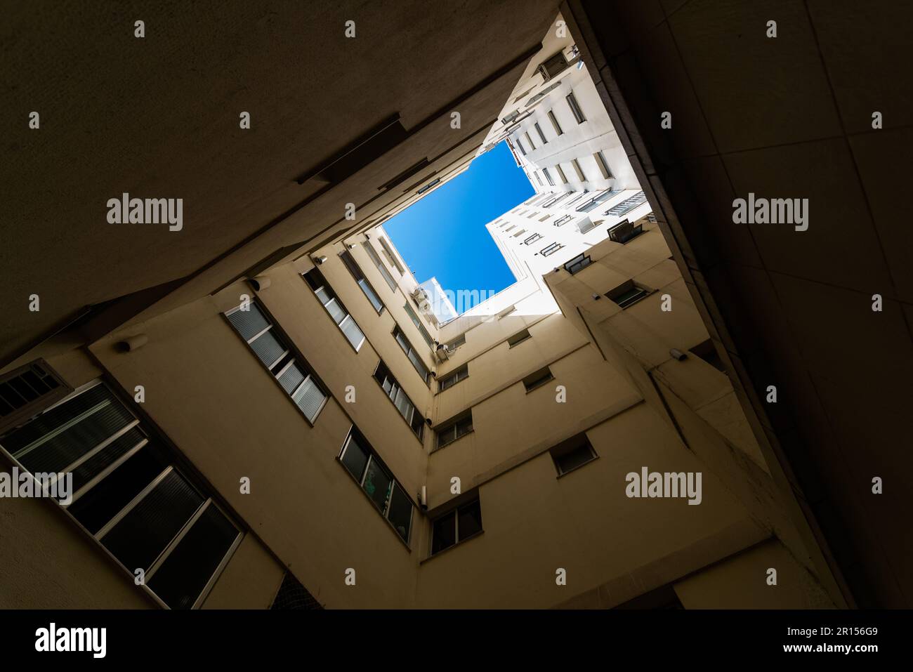 A low-angle shot of the narrow square-shaped space between a building ...