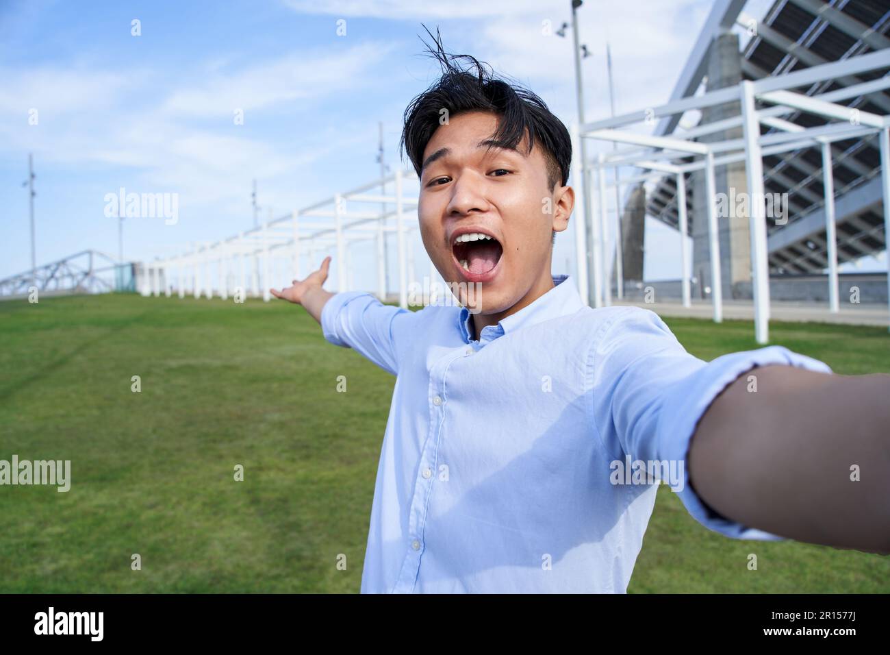 Selfie portrait looking at camera of surprised Asian teenager pointing ...