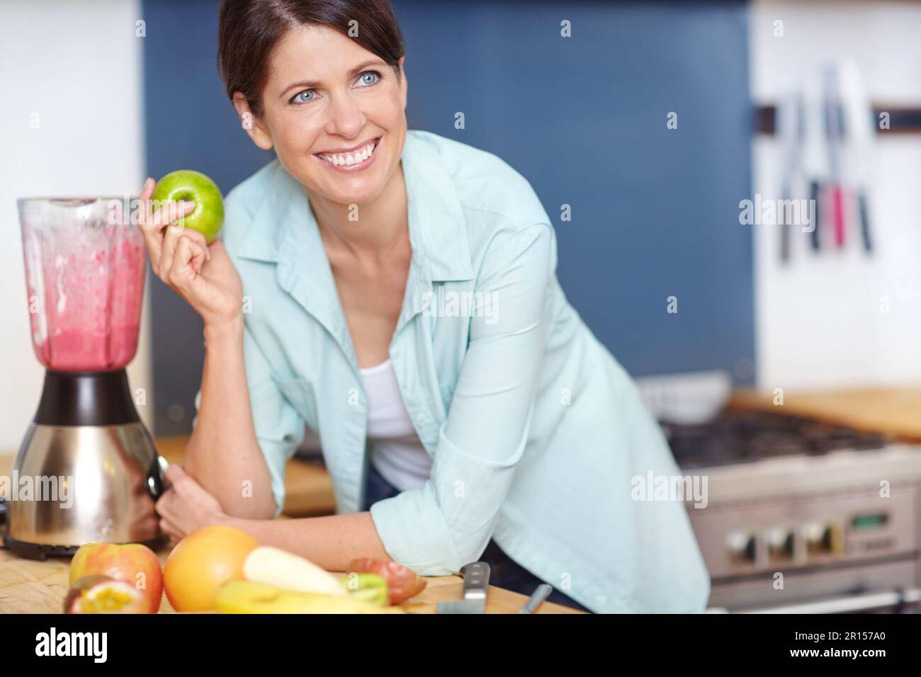 Get ready to enjoy an awesome fruit smoothie. an attractive woman ...