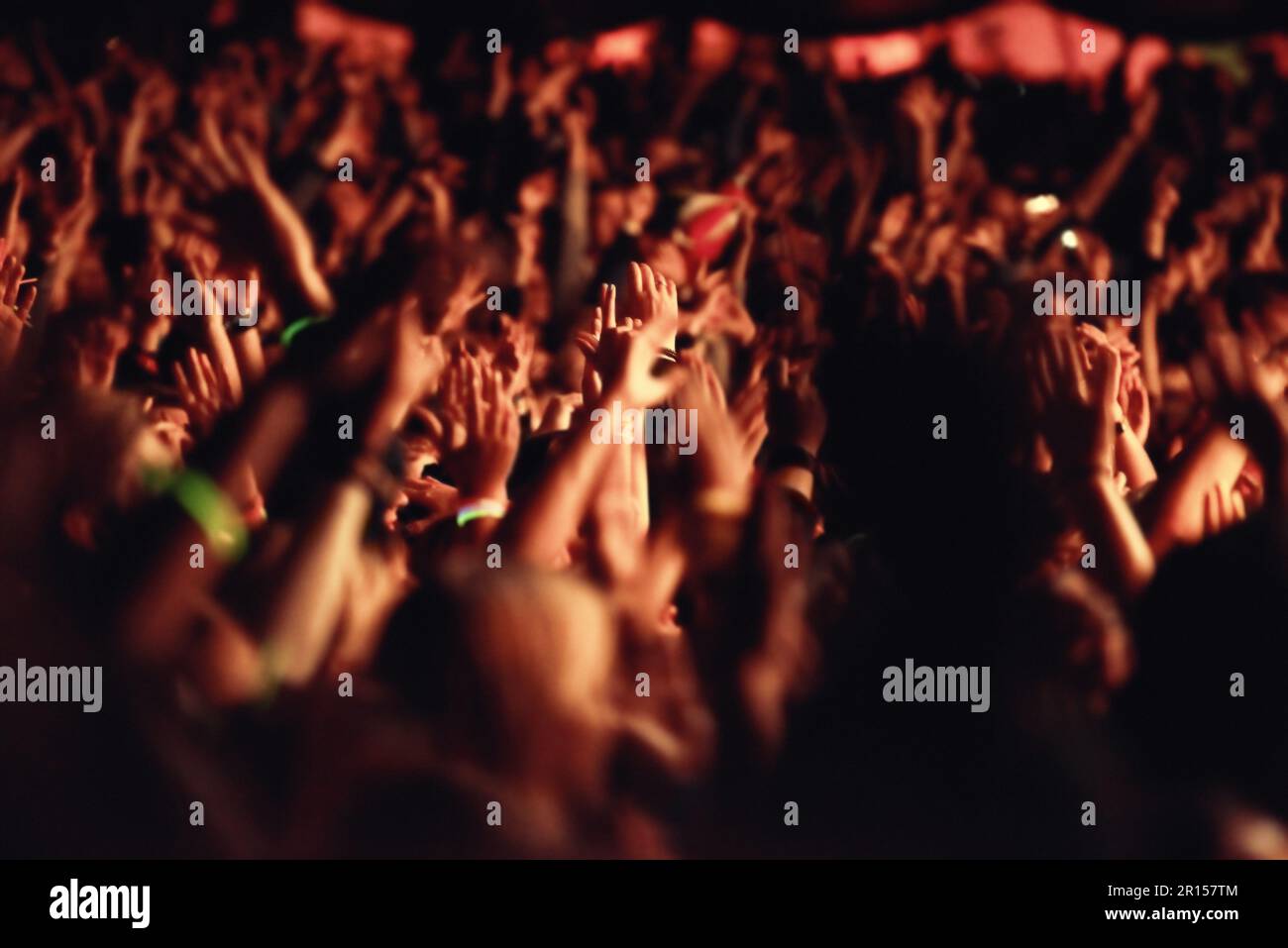 Palpable excitement. An audience with hands raised at an outdoors ...