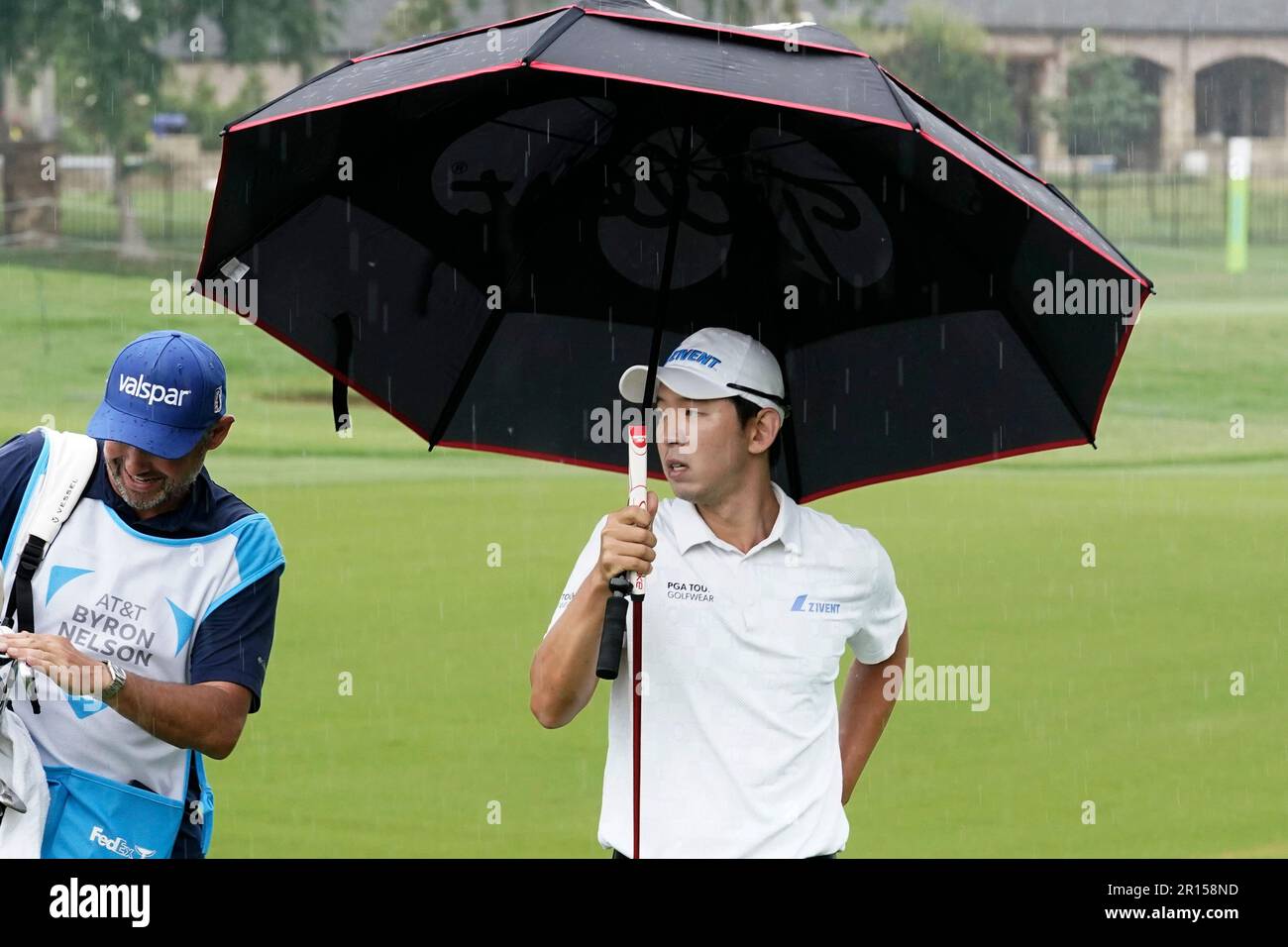 S.Y. Noh, of South Korea, uses an umbrella to keep dry during the first ...