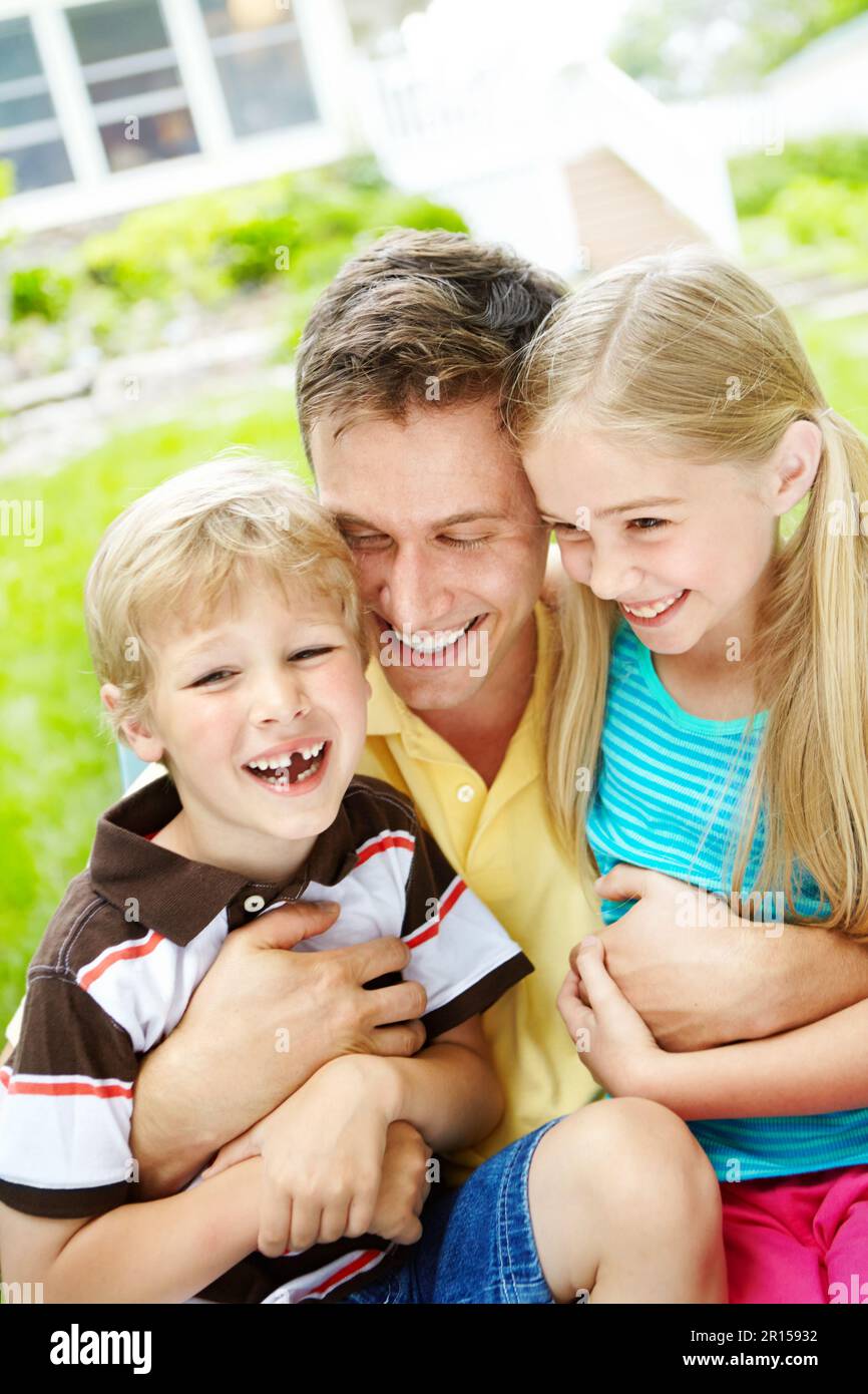 Dads little treasures. Handsome young father holding his two children with a happy smile Stock ...
