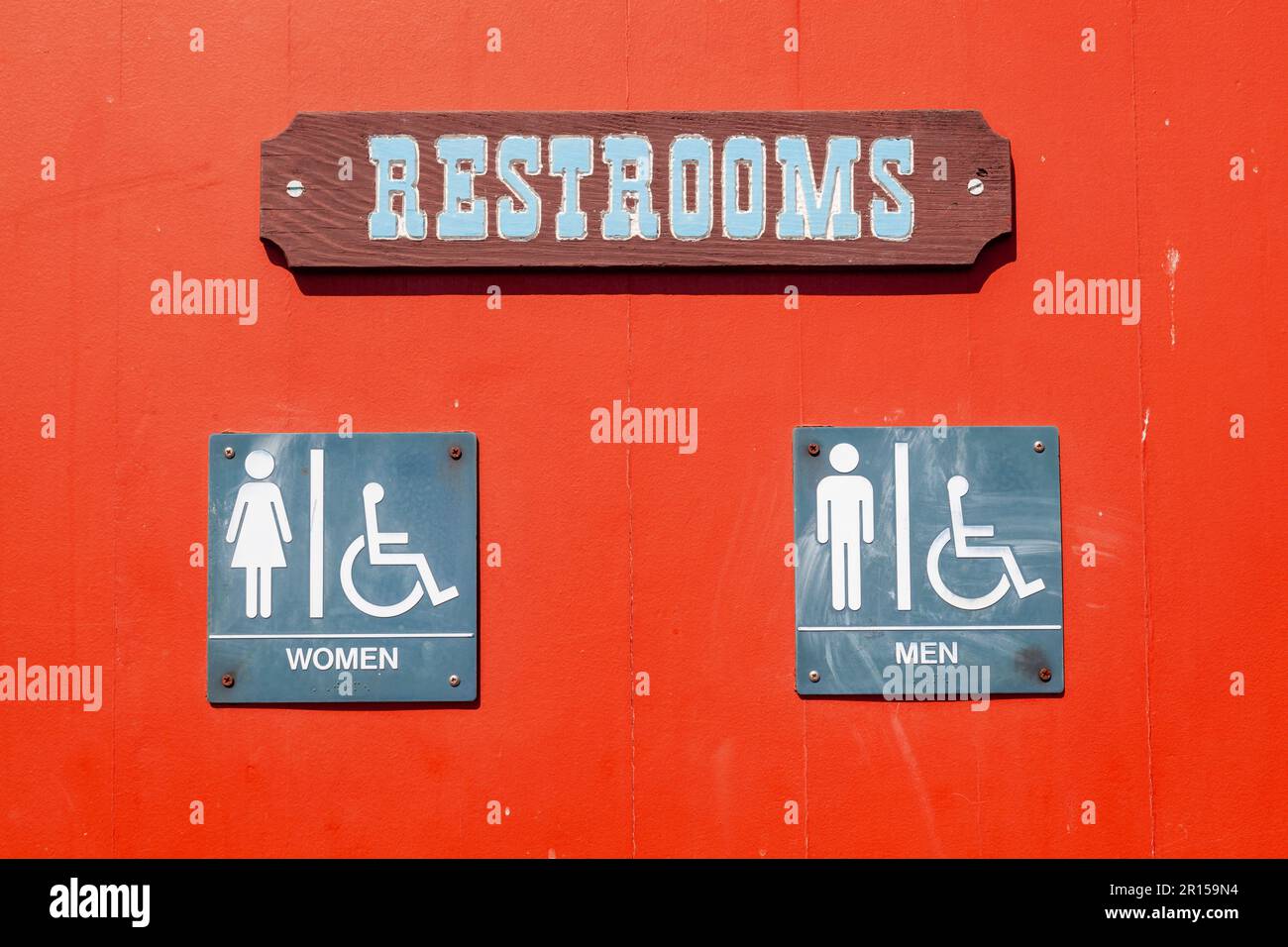 sign restroom in metal at a red wall with shadow Stock Photo - Alamy
