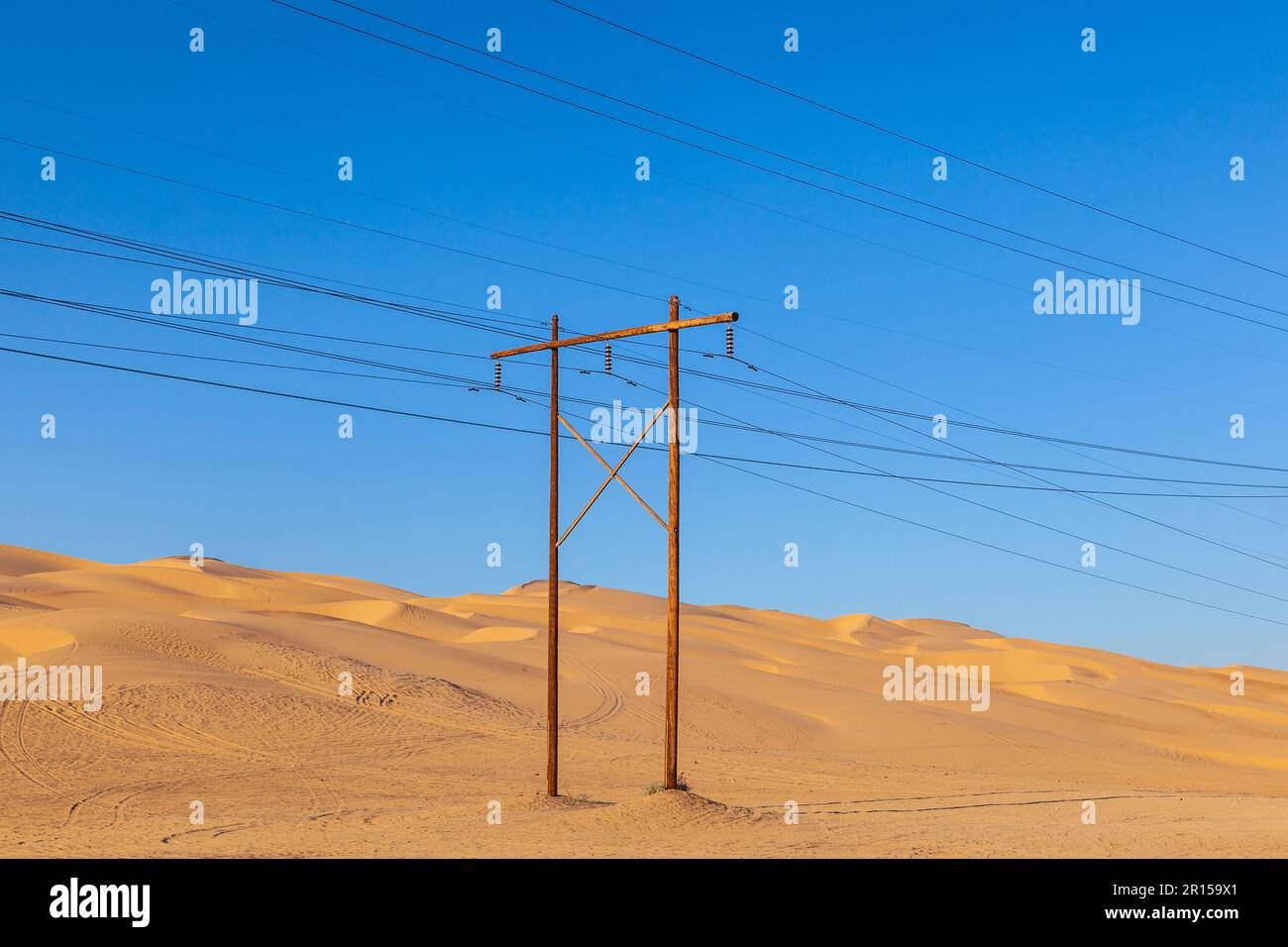 electric pylon in the desert with wooden pile under blue sky Stock ...