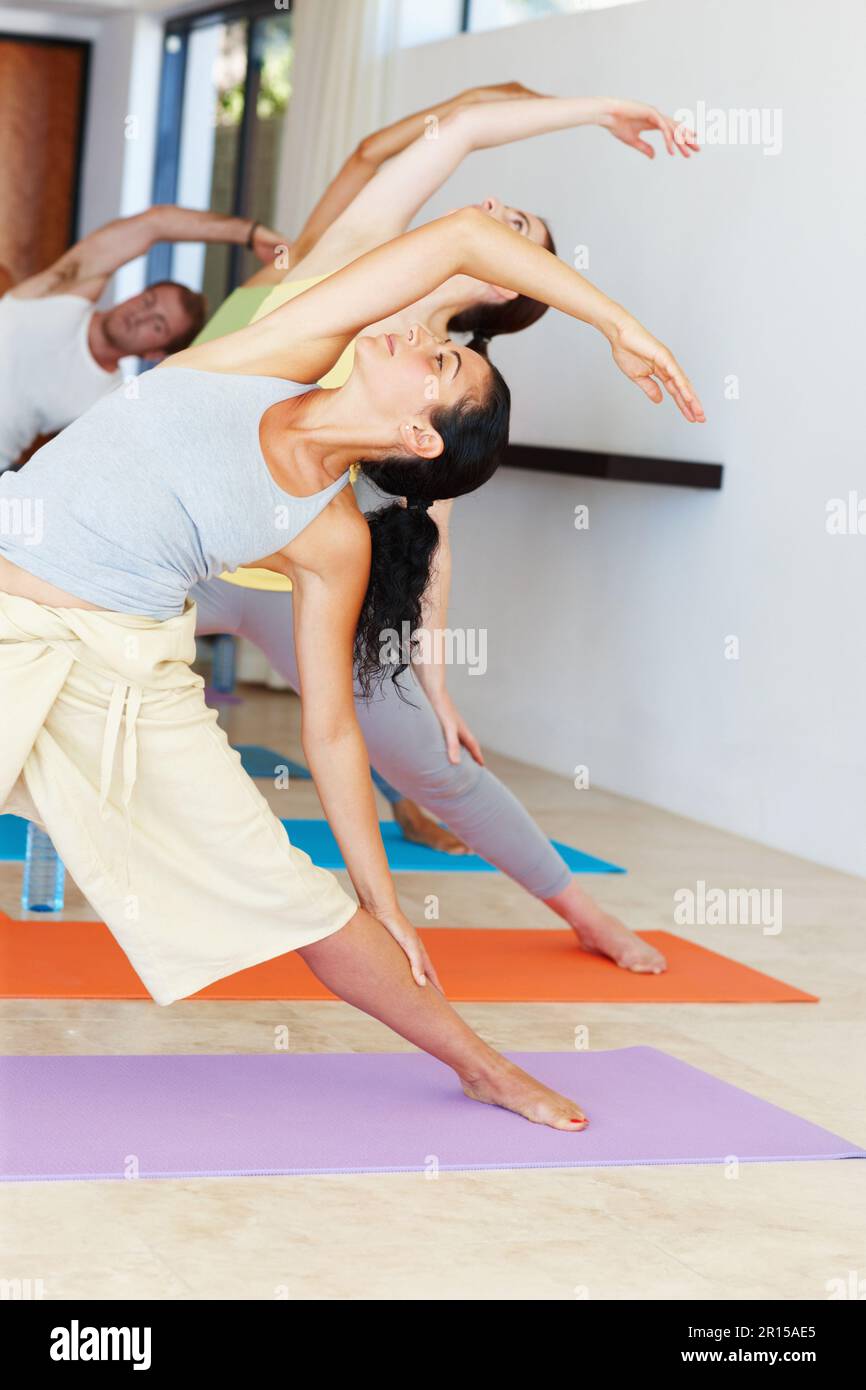 Stretching their way to health. a diverse group of yoga students ...