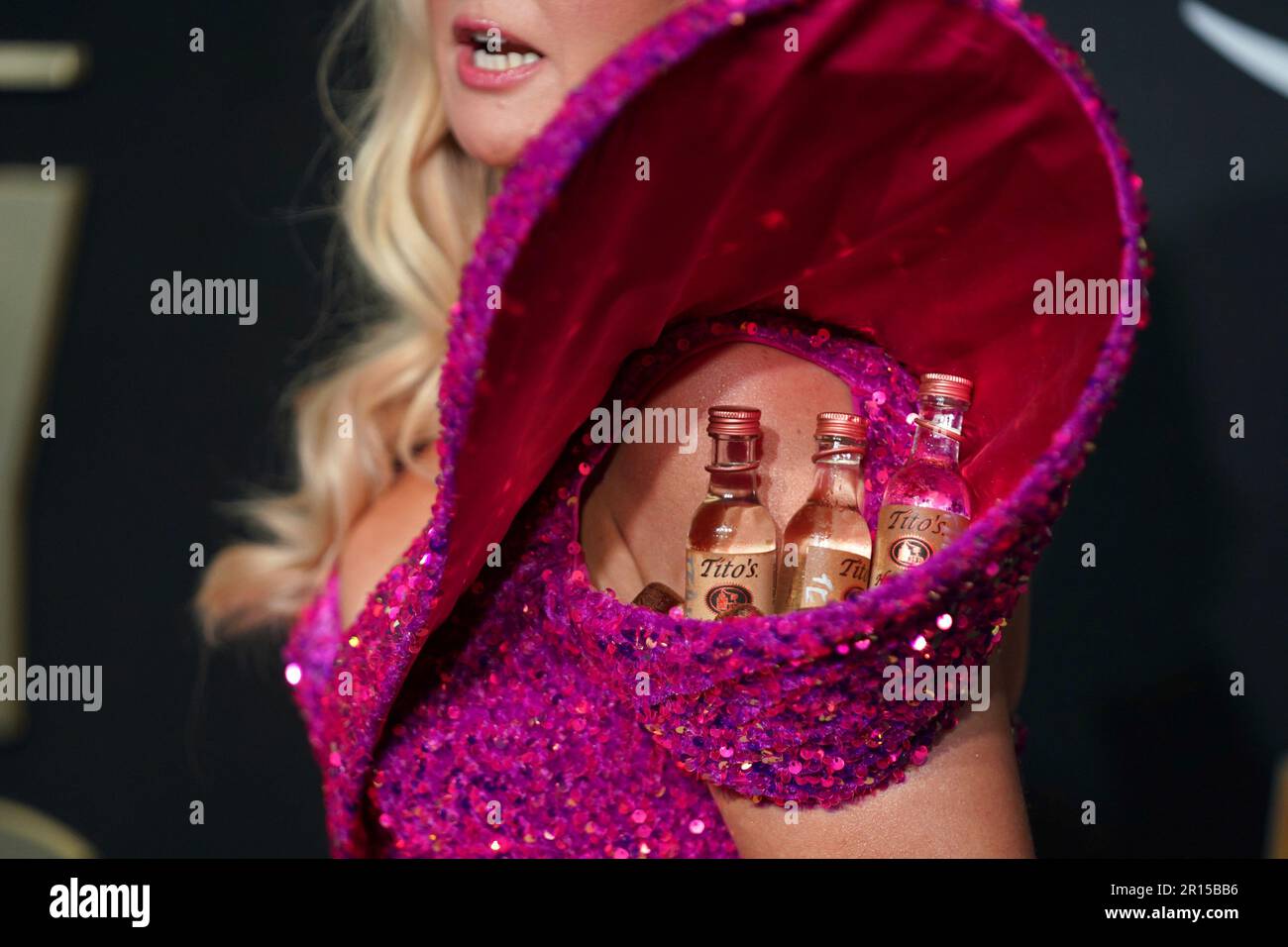 Pillbox Patti arrives wearing a dress with miniature bottles of vodka ...