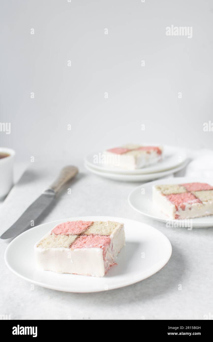 Top view of battenburg cake slice in a white plate, almond and ...