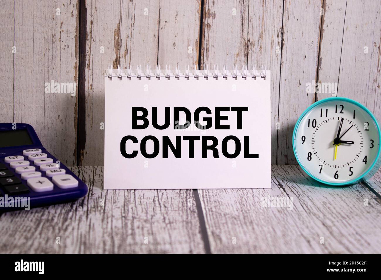 Budget Control. Burning sheet of paper with text on a rusty metal background Stock Photo - Alamy