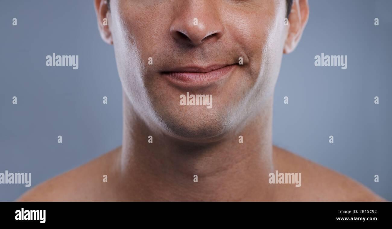 Almost...Cropped studio shot of the lower half of a young mans face ...