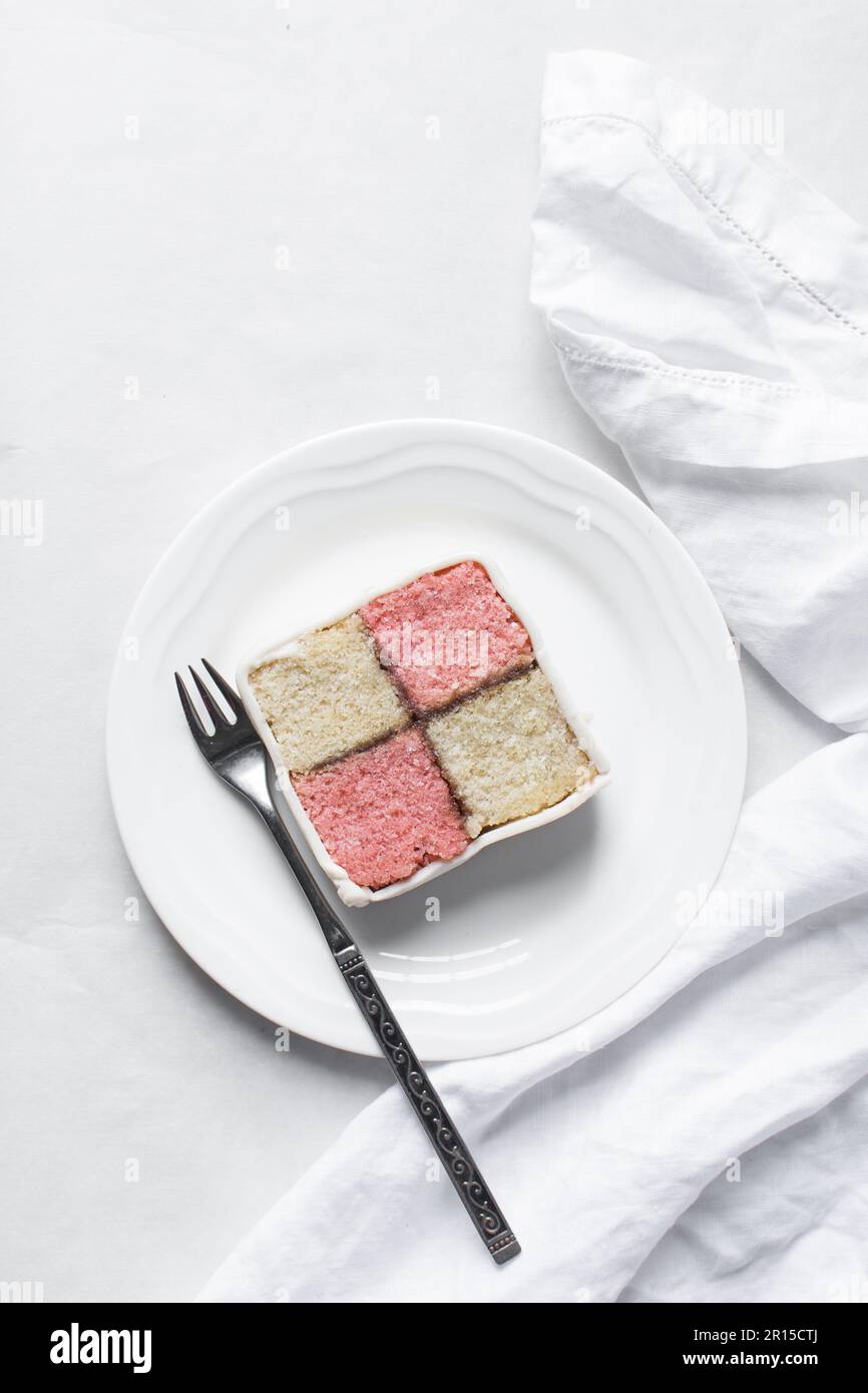Top view of battenburg cake slice in a white plate, almond and ...