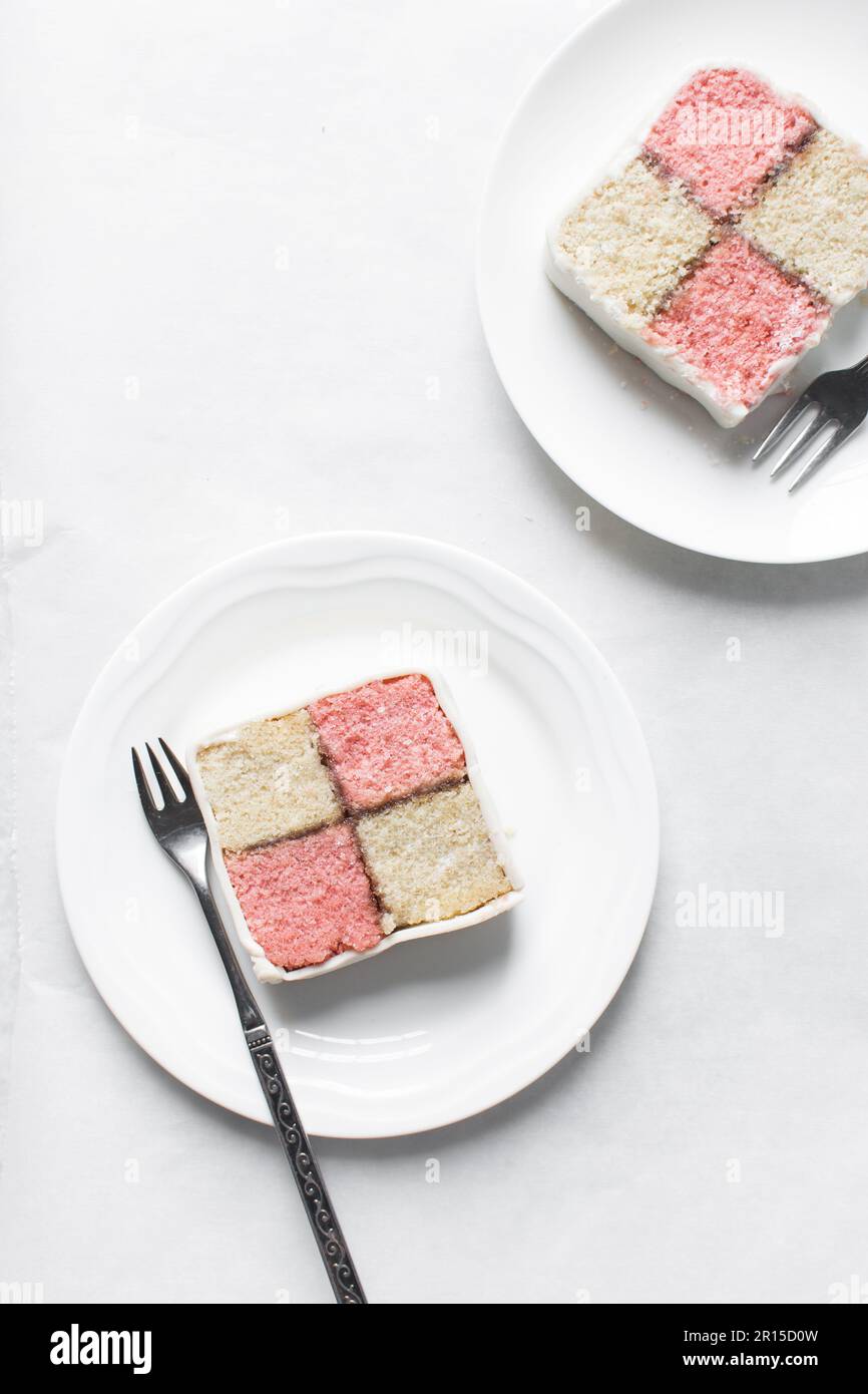 Top view of battenburg cake slice in a white plate, almond and ...