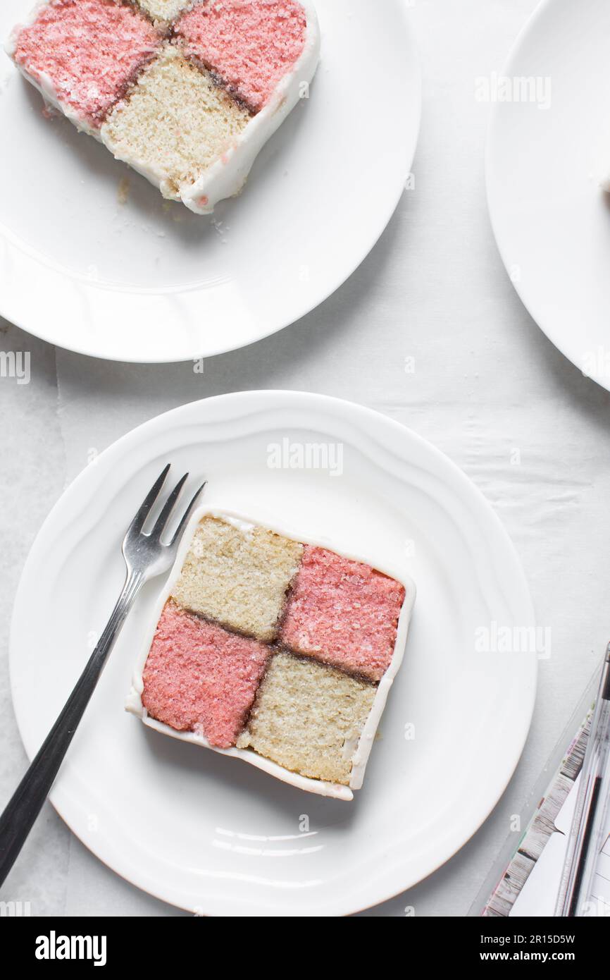 Top view of battenburg cake slice in a white plate, almond and ...