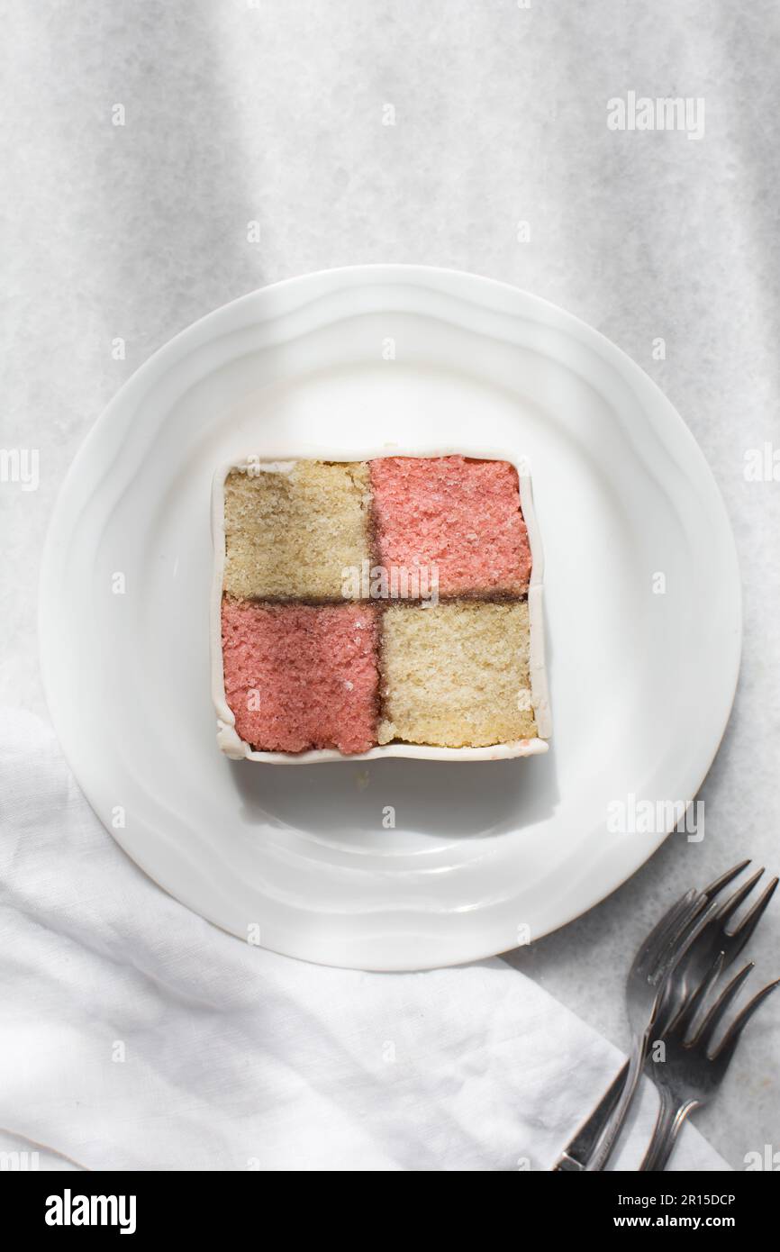 Top view of battenburg cake slice in a white plate, almond and ...
