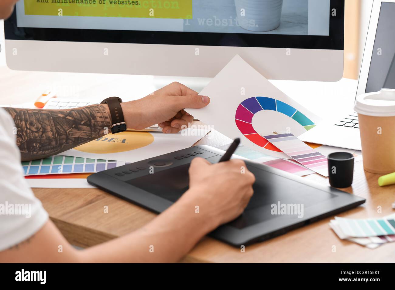 Male graphic designer working with tablet and color palette in office ...