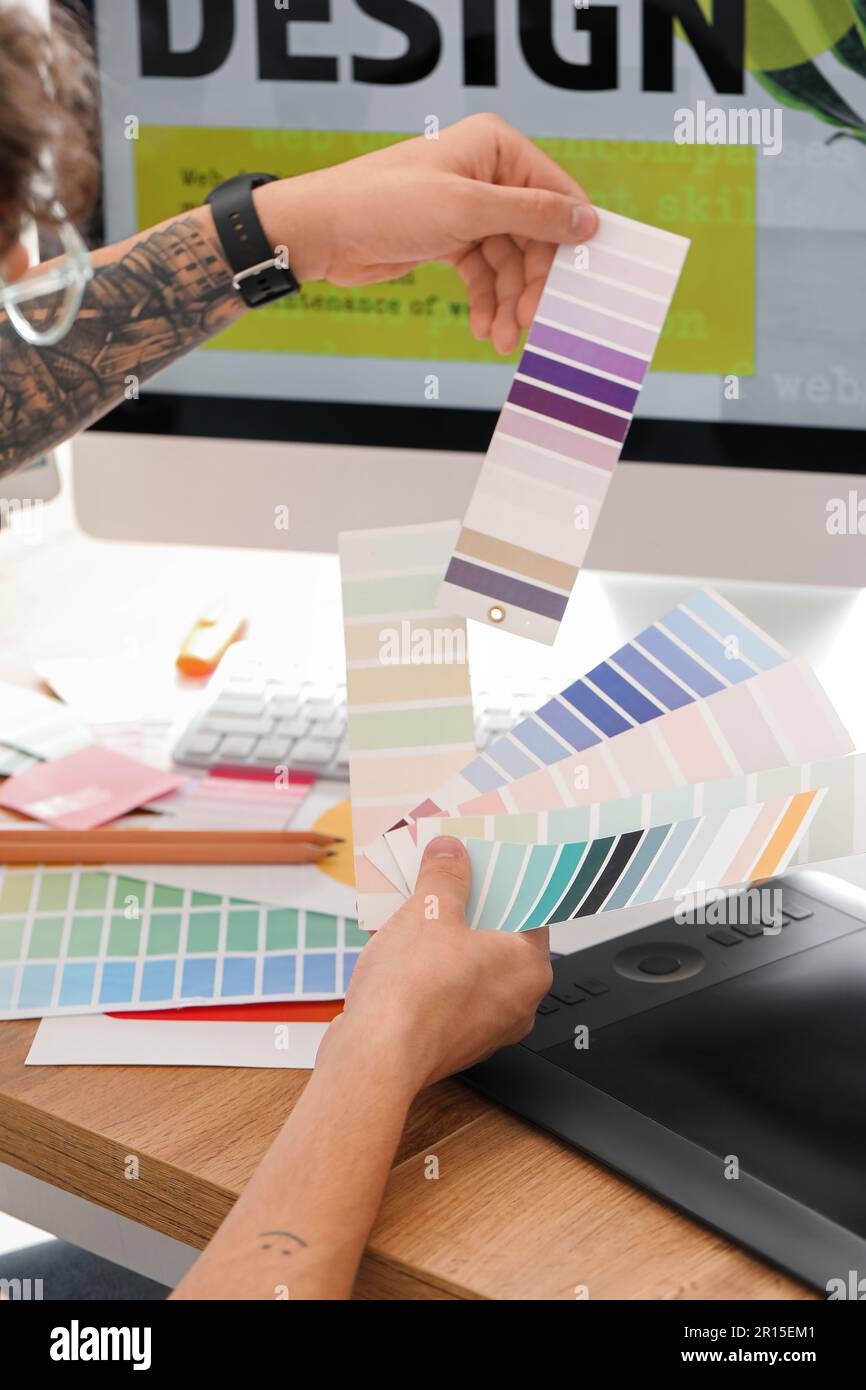 Male graphic designer working with color palettes in office, closeup ...