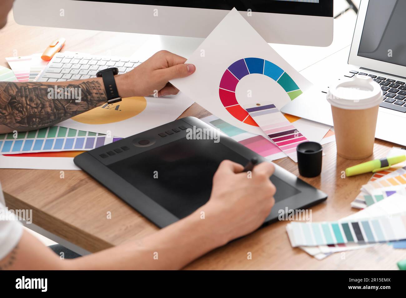 Male graphic designer working with tablet and color palette in office ...
