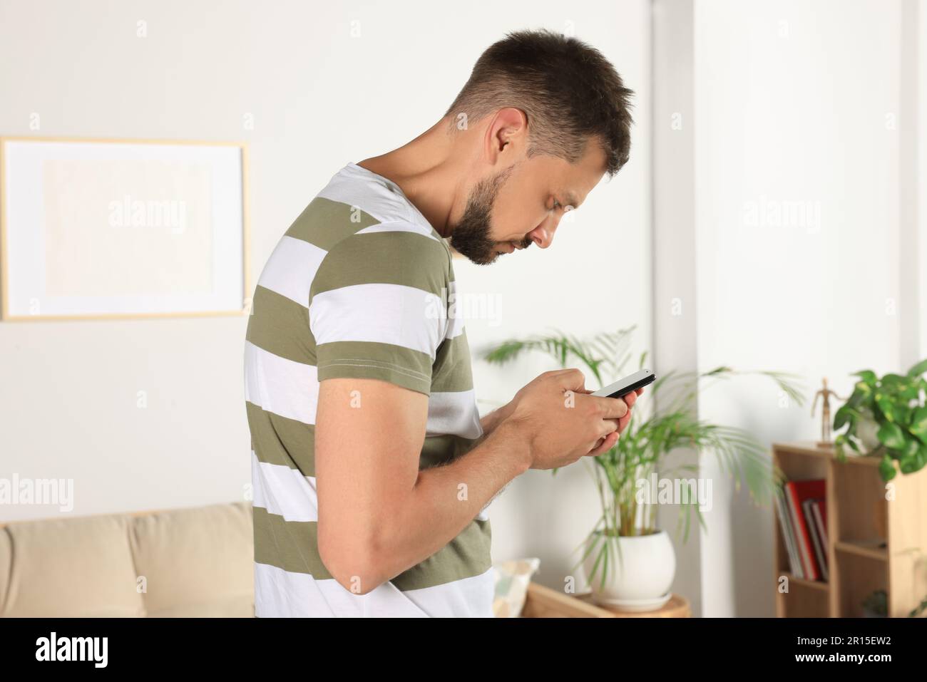 Man with poor posture using smartphone at home Stock Photo - Alamy