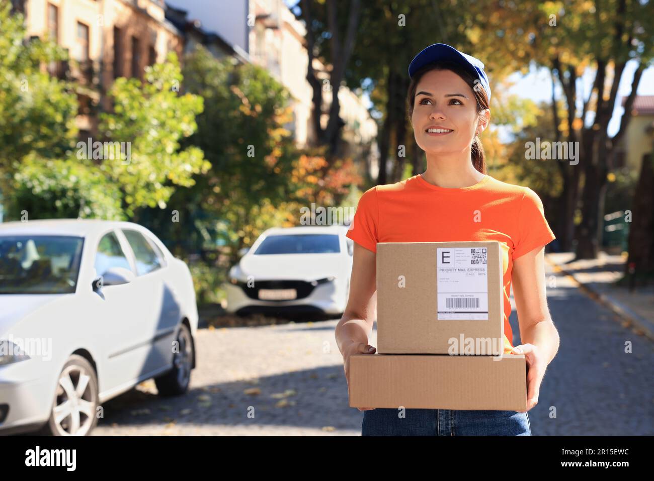 Courier carrying cardboard boxes on city street Stock Photo - Alamy