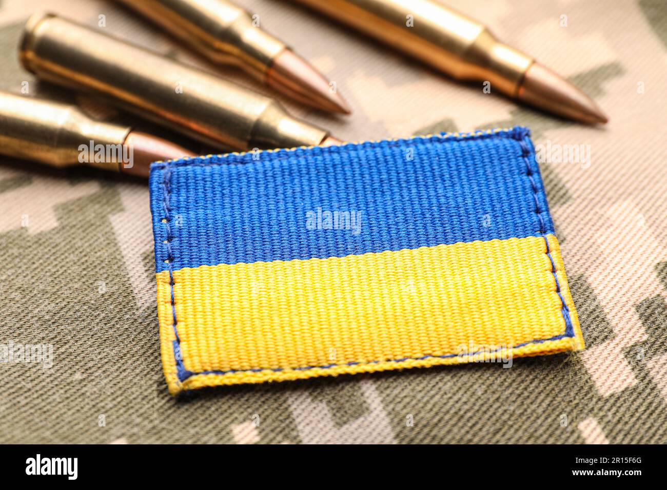 Military patch and bullets on pixel Ukrainian camouflage, closeup Stock ...
