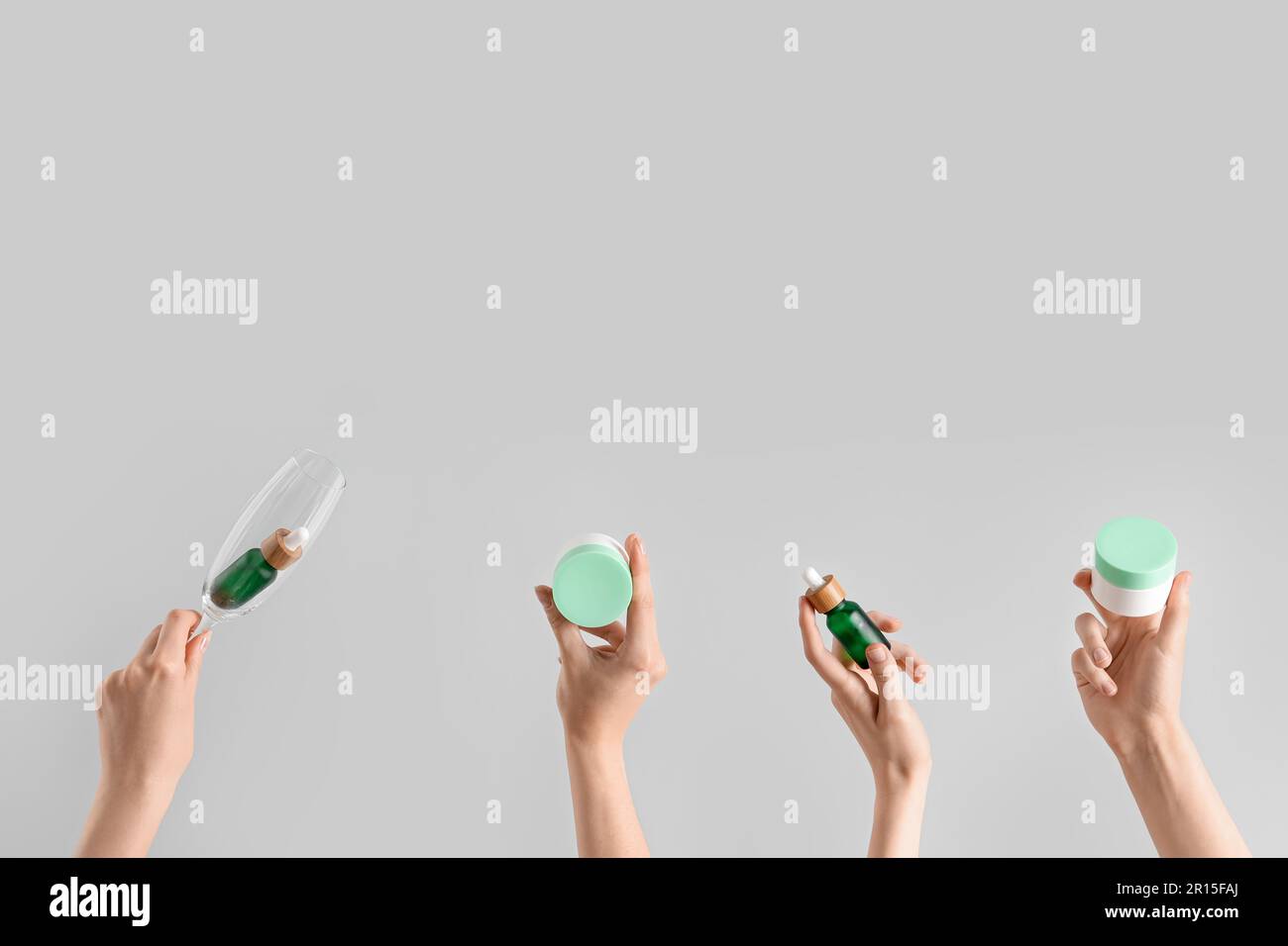 Hands holding different cosmetic products on light background Stock ...
