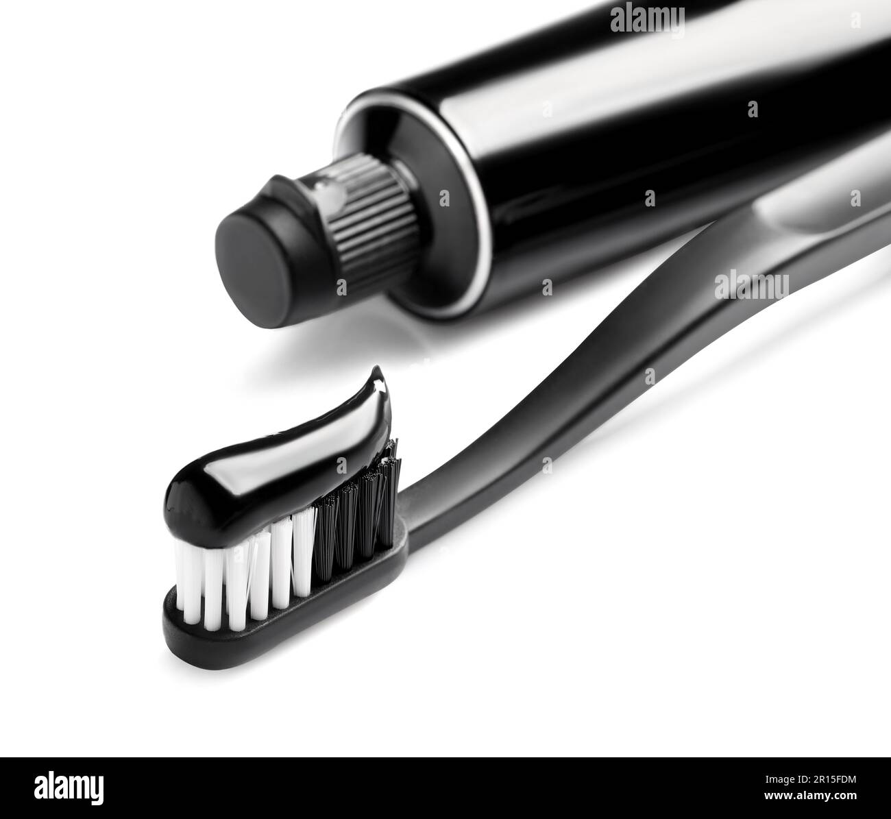 Tube of charcoal toothpaste and brush on white background Stock Photo ...