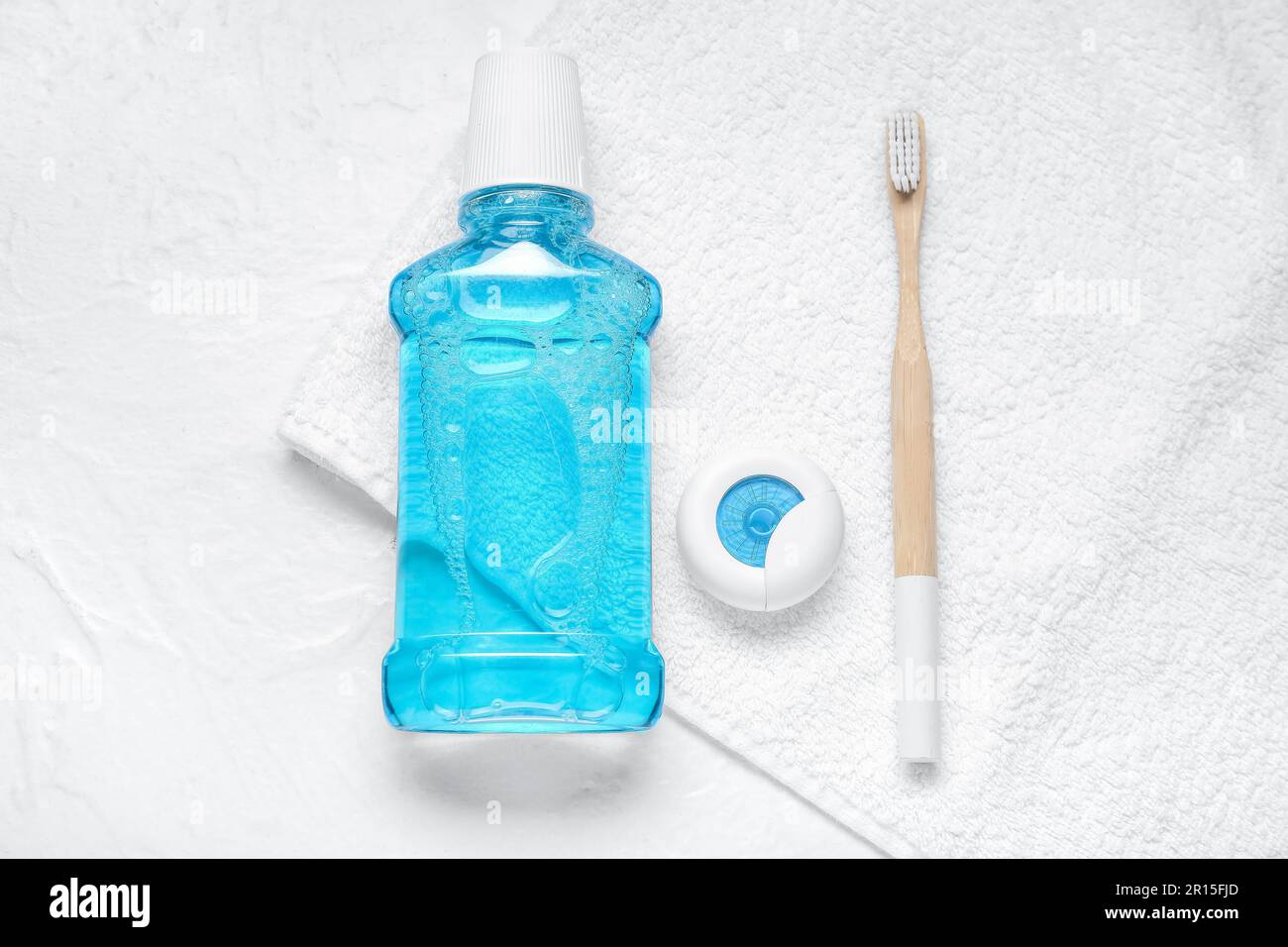 Dental floss, toothbrush and mouthwash on white towel Stock Photo - Alamy
