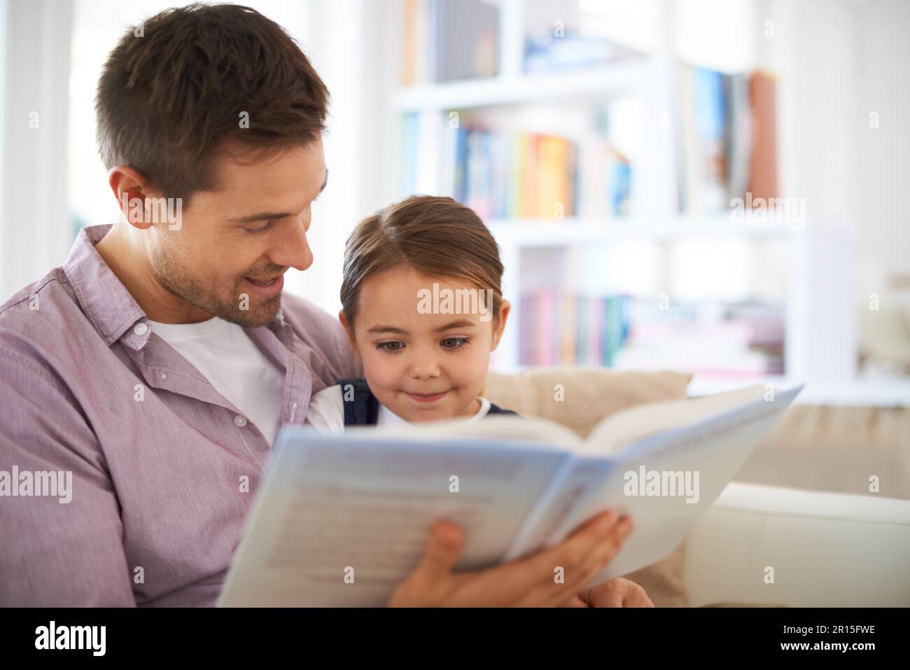 Education starts at home. a young father reading a book with his ...