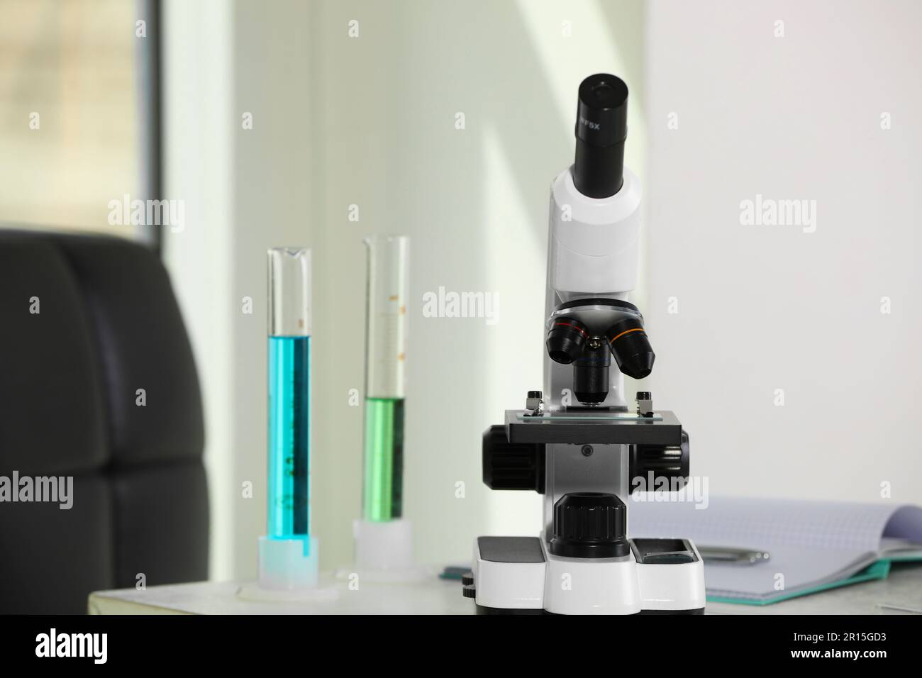 Modern microscope with glass slide on white table in laboratory, space ...