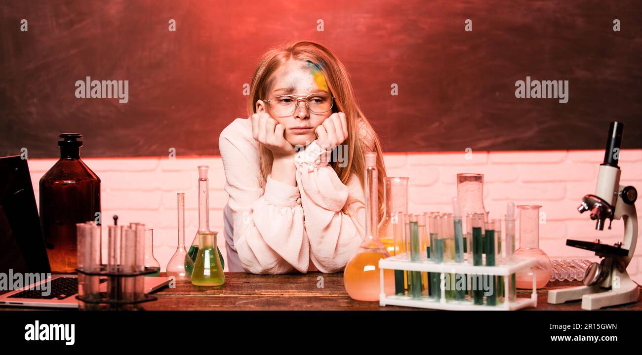 Funny sad schoolgirl scientist in the laboratory. Chemical experiment ...