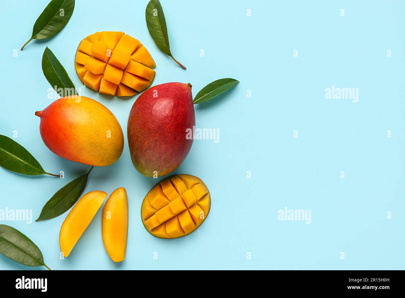 Fresh ripe mangoes on light blue background Stock Photo - Alamy