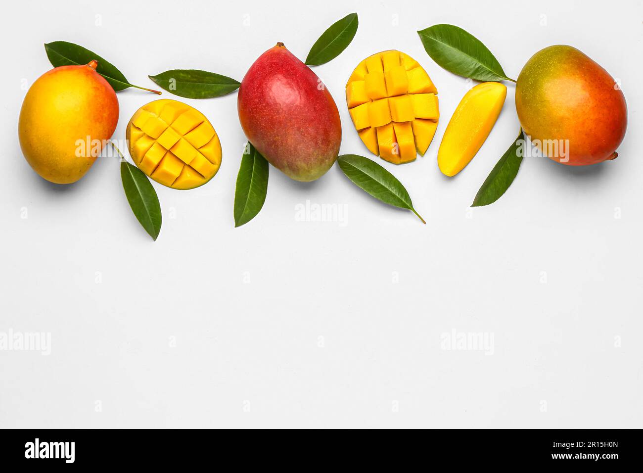 Fresh ripe mangoes on light background Stock Photo - Alamy