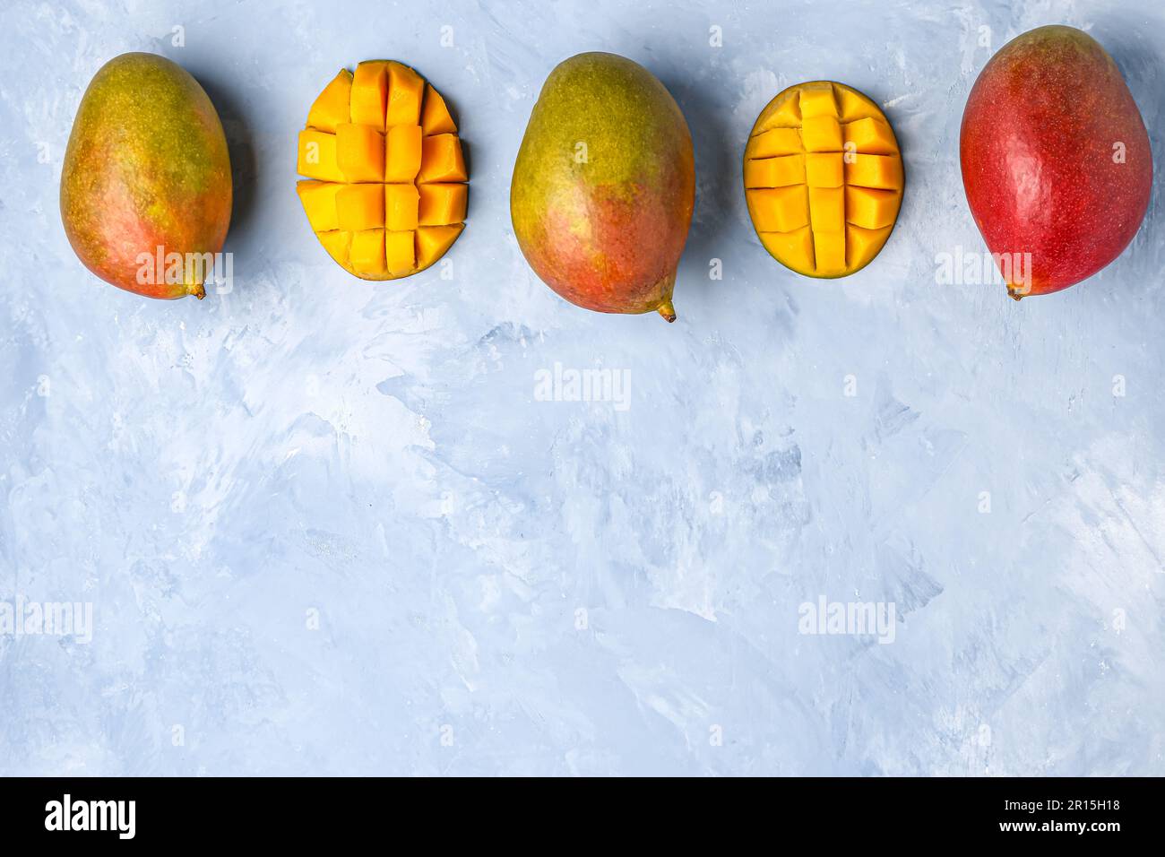 Fresh ripe mangoes on light blue background Stock Photo - Alamy