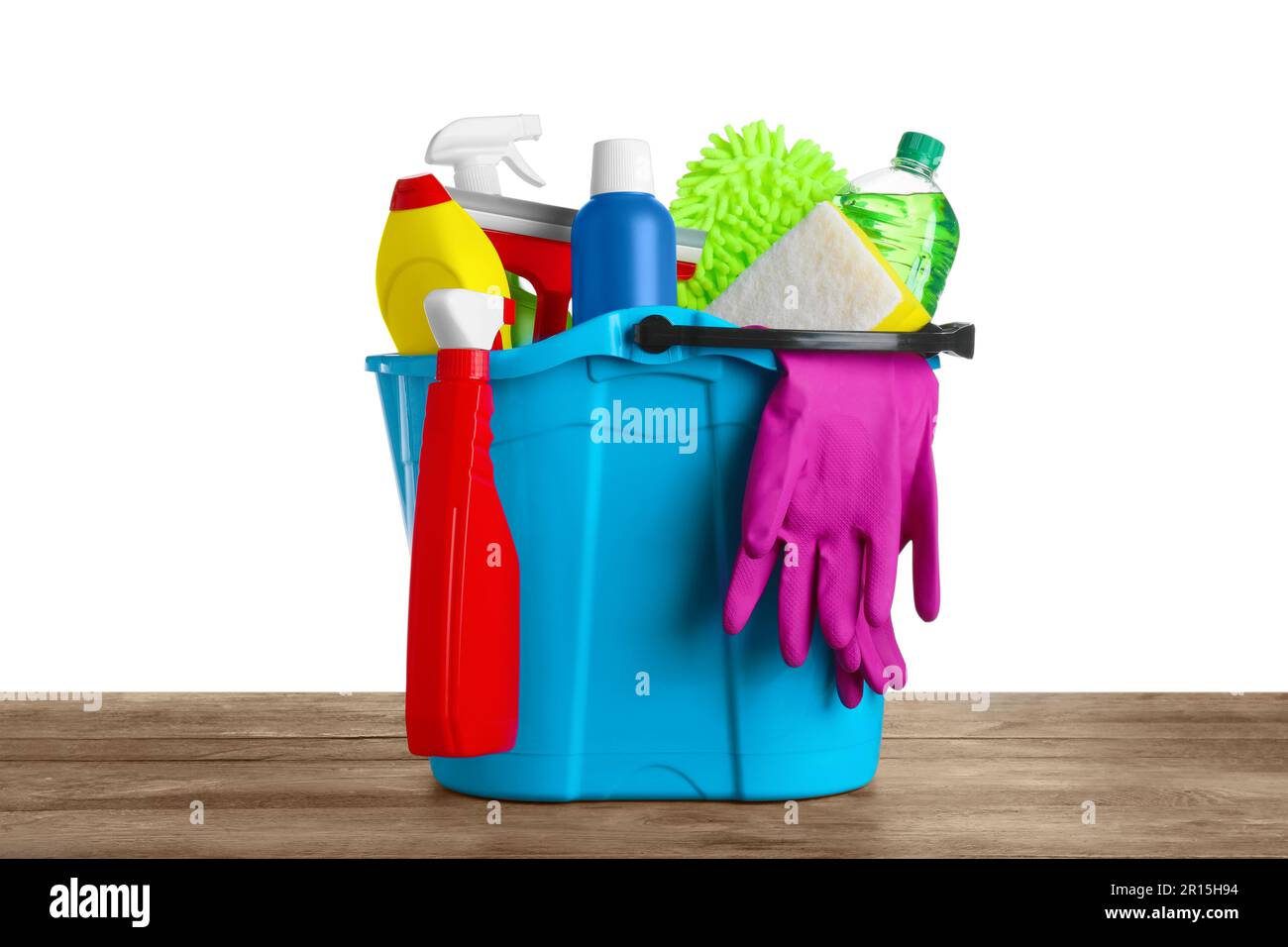Bucket with many different car wash products on wooden table against ...