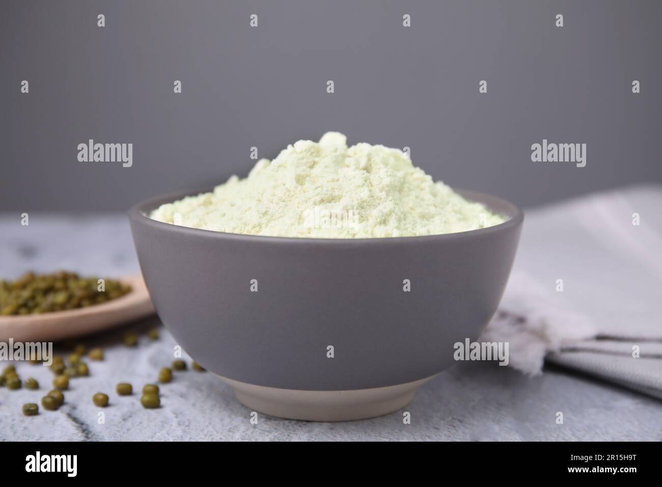 Mung bean flour in bowl and seeds on white textured table Stock Photo ...