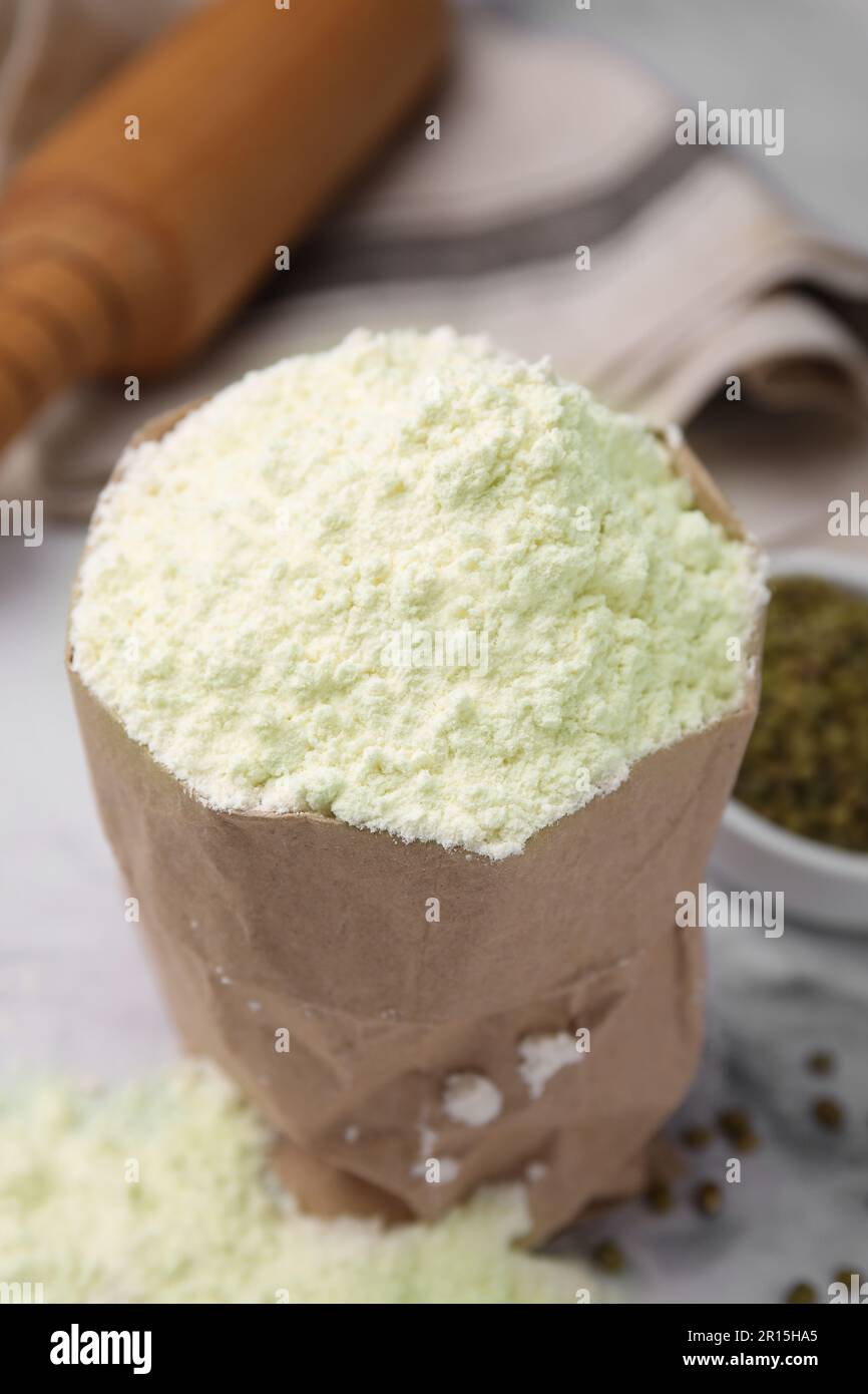 Mung bean flour in paper bag and seeds on white marble table, closeup ...