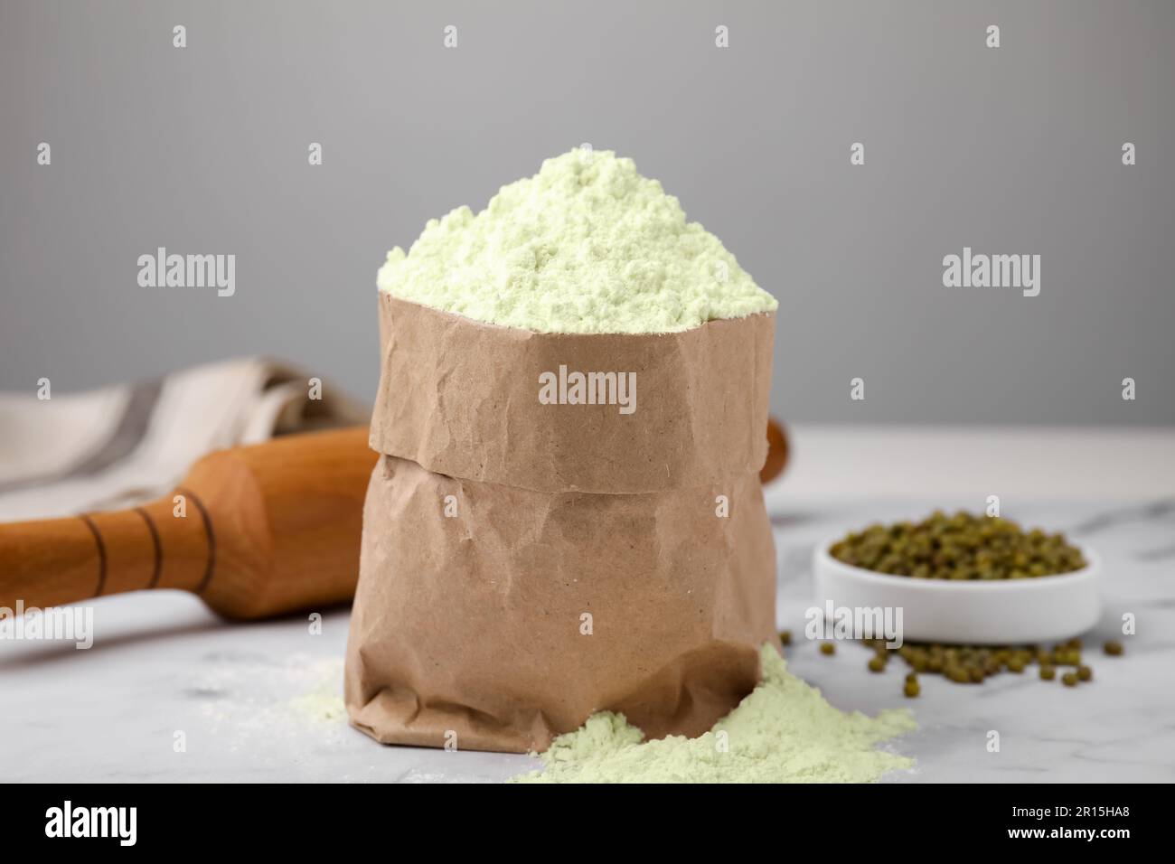 Mung bean flour in paper bag and seeds on white marble table Stock ...
