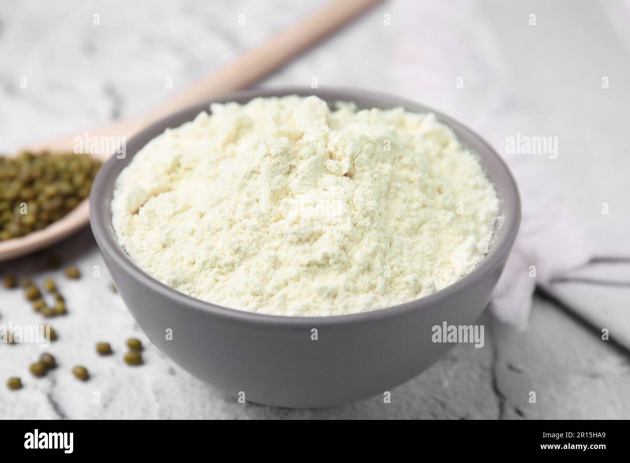 Mung bean flour in bowl and seeds on white textured table Stock Photo ...