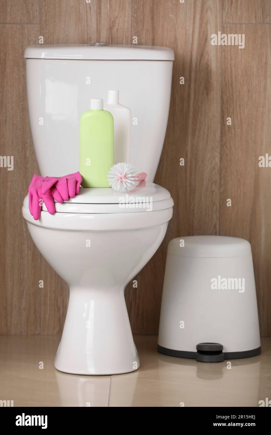 Different cleaning supplies on toilet bowl indoors Stock Photo - Alamy