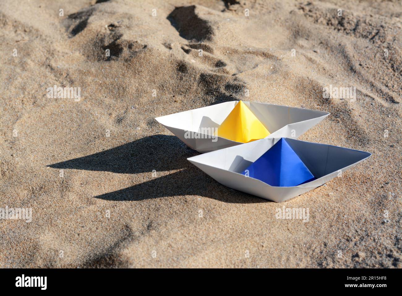 Two color paper boats on sandy beach Stock Photo - Alamy