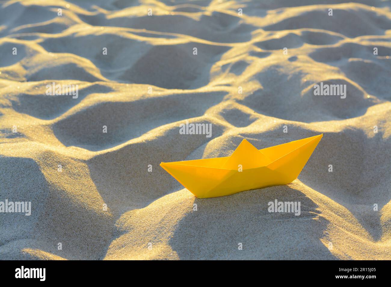 Beautiful yellow paper boat on sand outdoors, space for text Stock ...