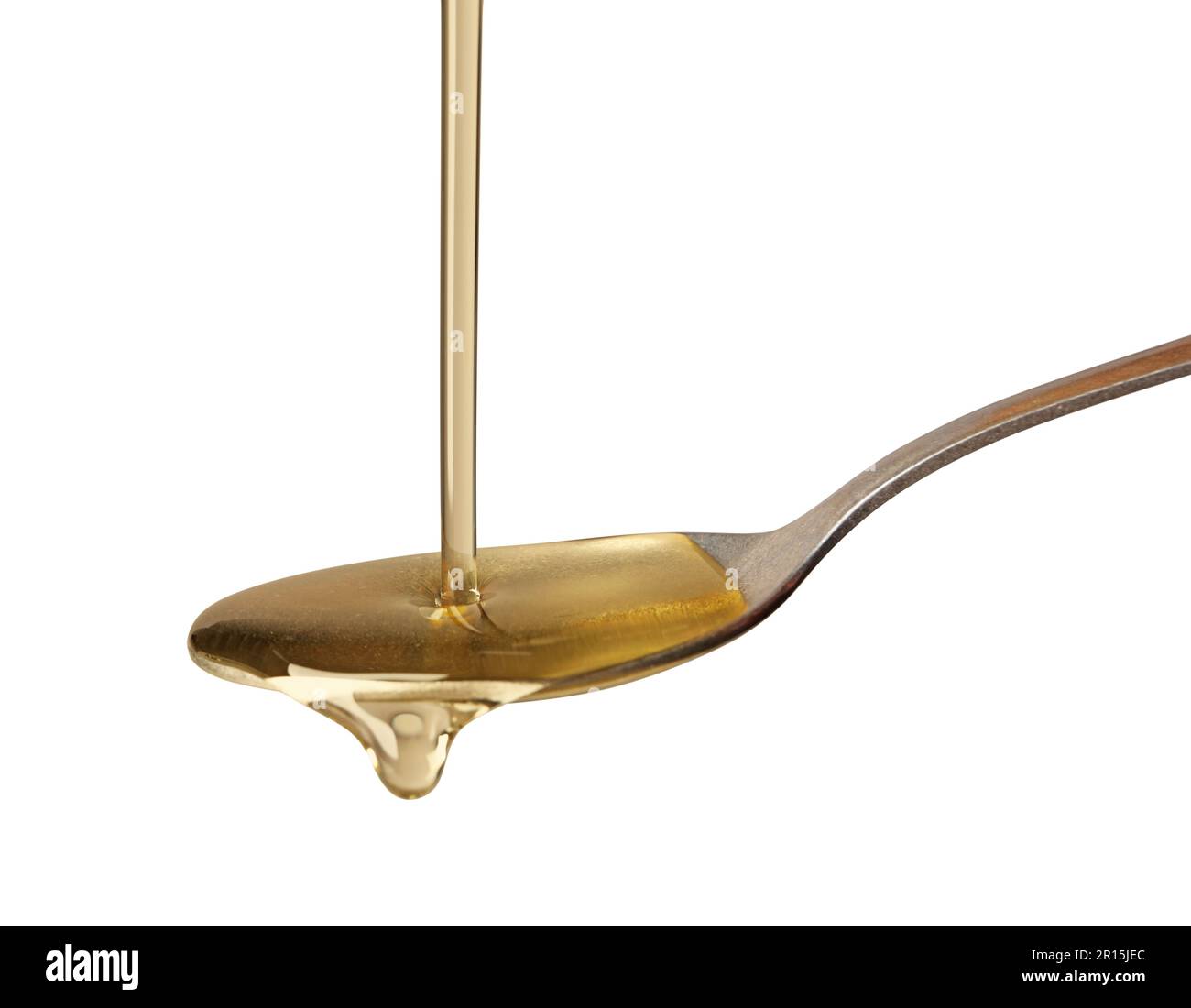 Pouring cooking oil into spoon on white background Stock Photo - Alamy