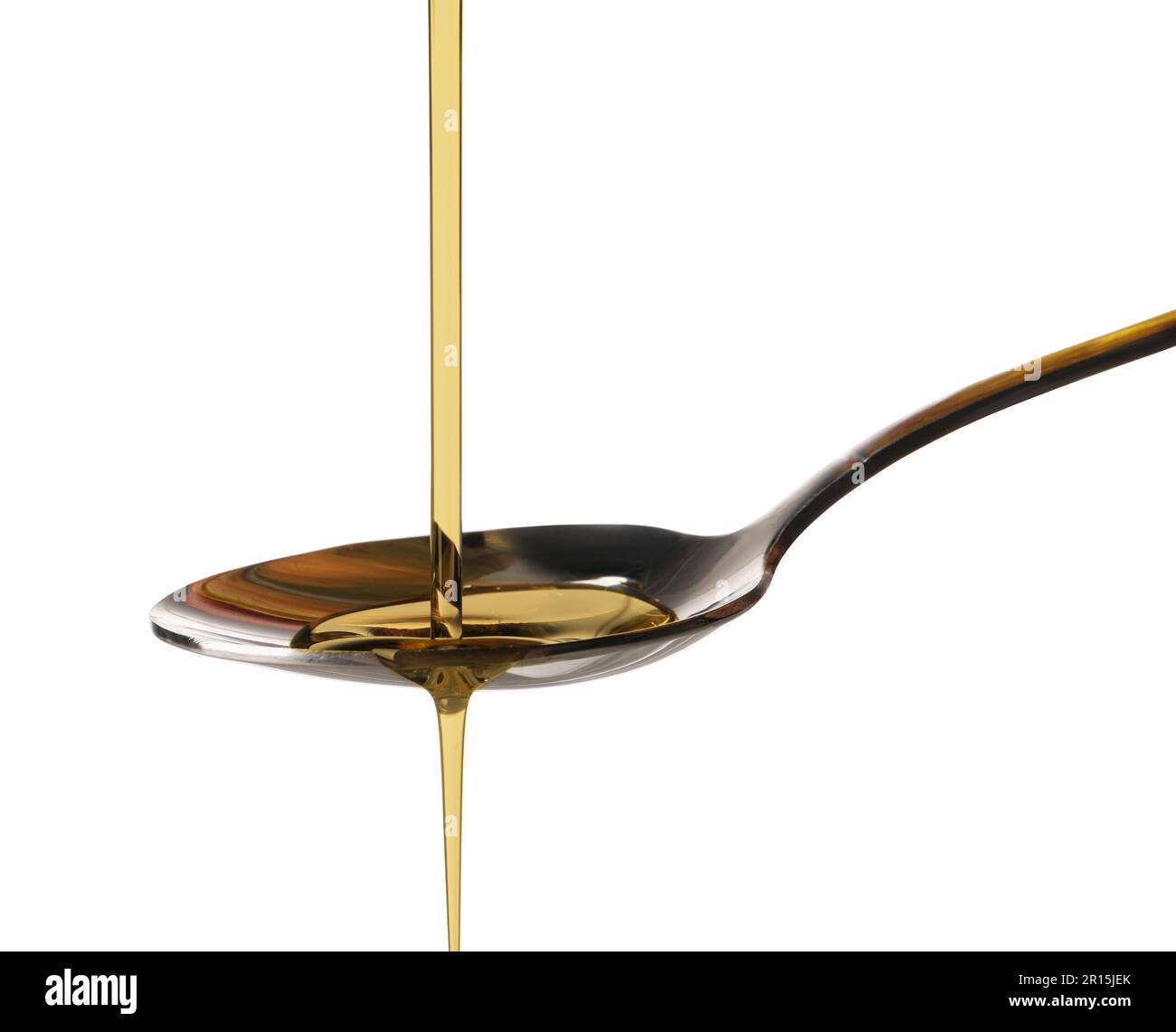 Pouring cooking oil into spoon on white background Stock Photo - Alamy