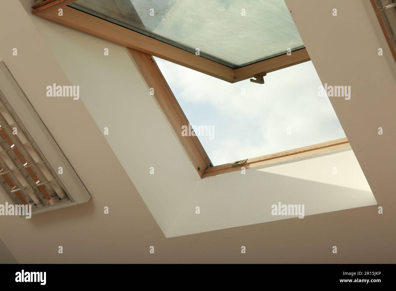 Open skylight roof window on slanted ceiling in attic room, low angle view Stock Photo - Alamy