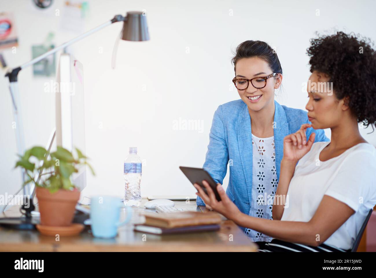 Churning out the ideas together. two coworkers using a digital tablet ...