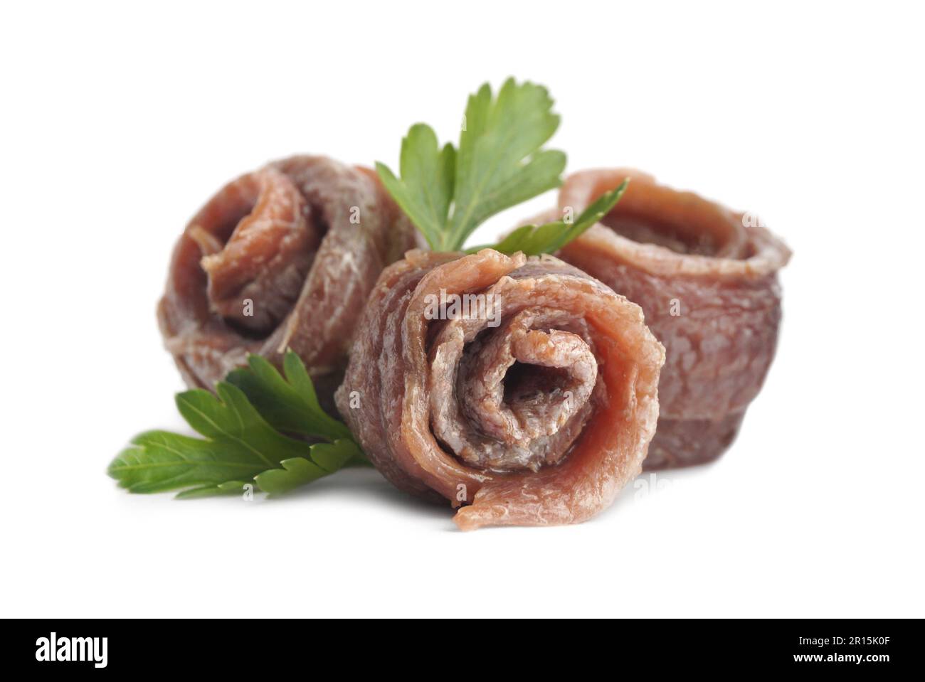 Delicious rolled anchovy fillets and parsley on white background Stock ...