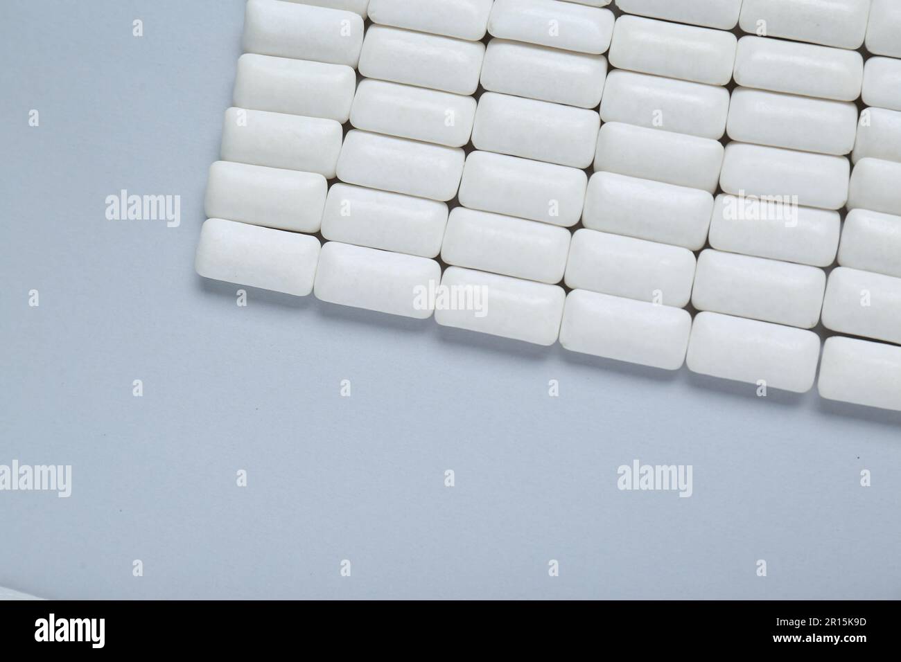 Tasty white chewing gums on light grey background, flat lay. Space for ...