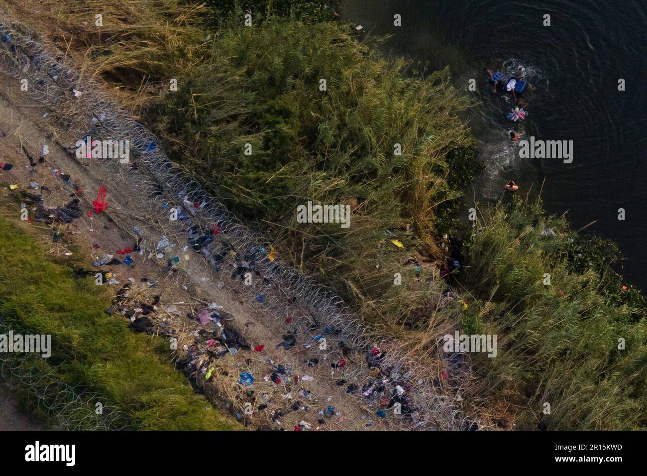 Migrants use a raft to cross the Rio Grande at the Texas-Mexico border ...