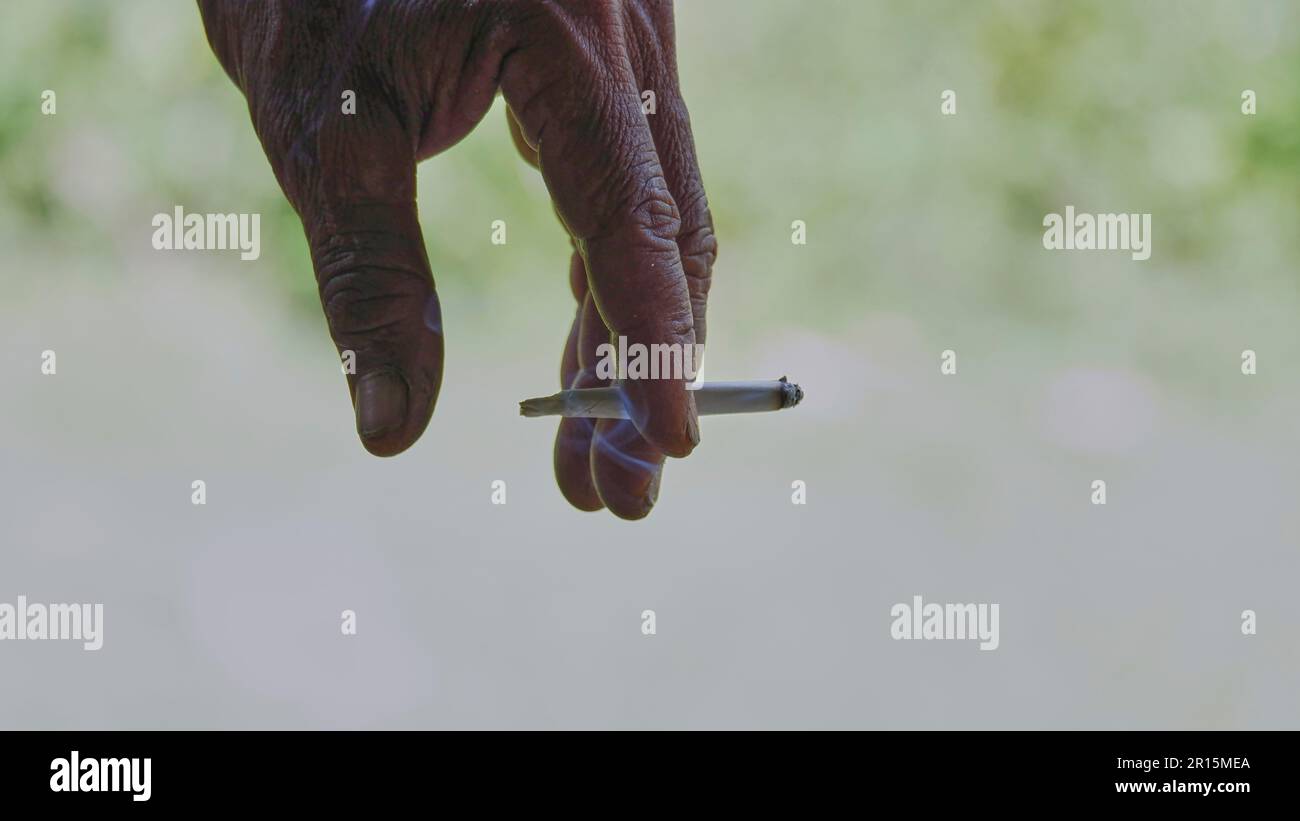 A hand holding a cigarette between the index and middle fingers Stock ...