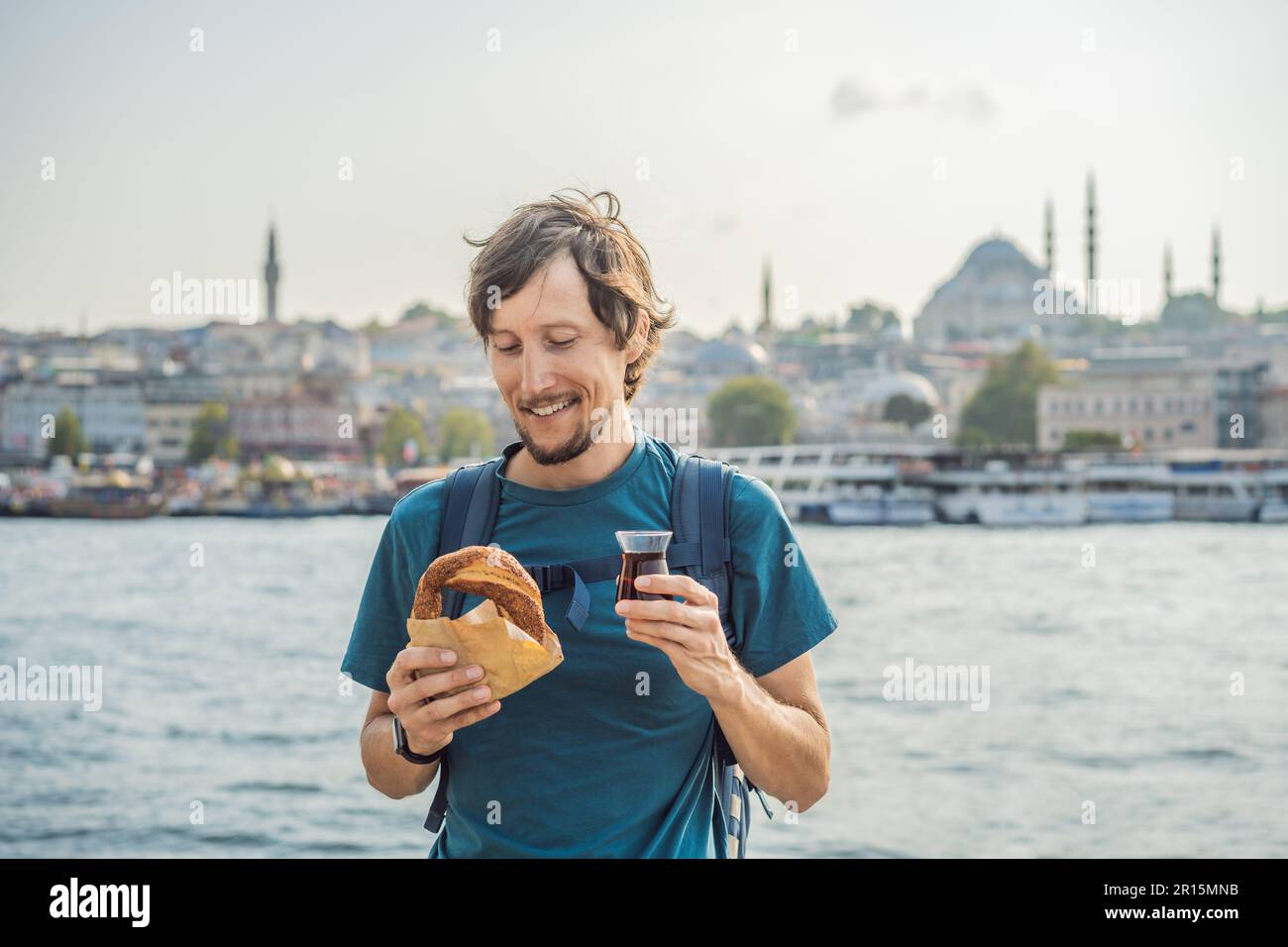 Man in Istanbul having breakfast with Simit and a glass of Turkish tea ...